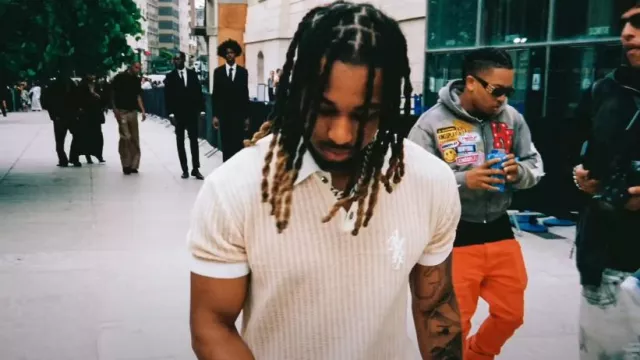 Amiri Cream Staggered Logo Polo worn by DDG in DDG - She Ain't Leaving ...